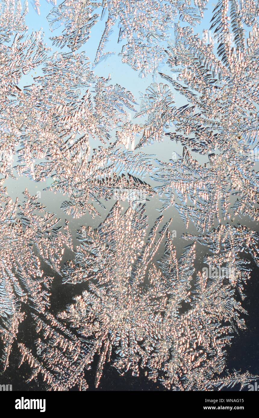 Snowflakes frost rime macro on window glass pane. Colorful ice on the ...