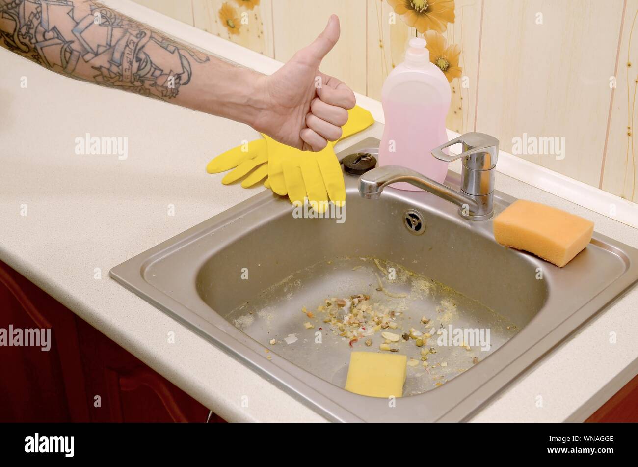 Hand of a young tattooed guy shows like on the background of a dirty ...