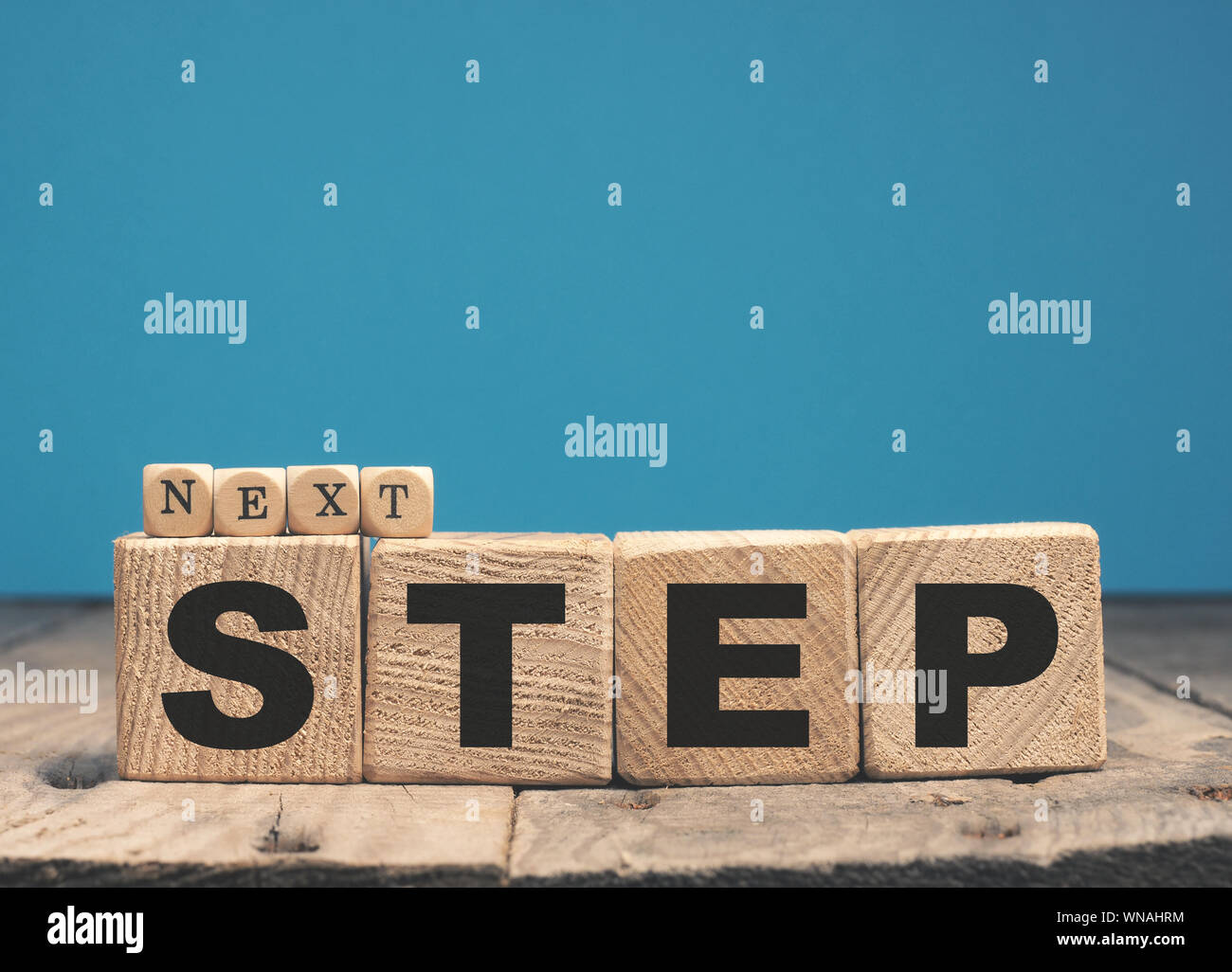 Wooden blocks with the words Next step, motivation or career concept ...