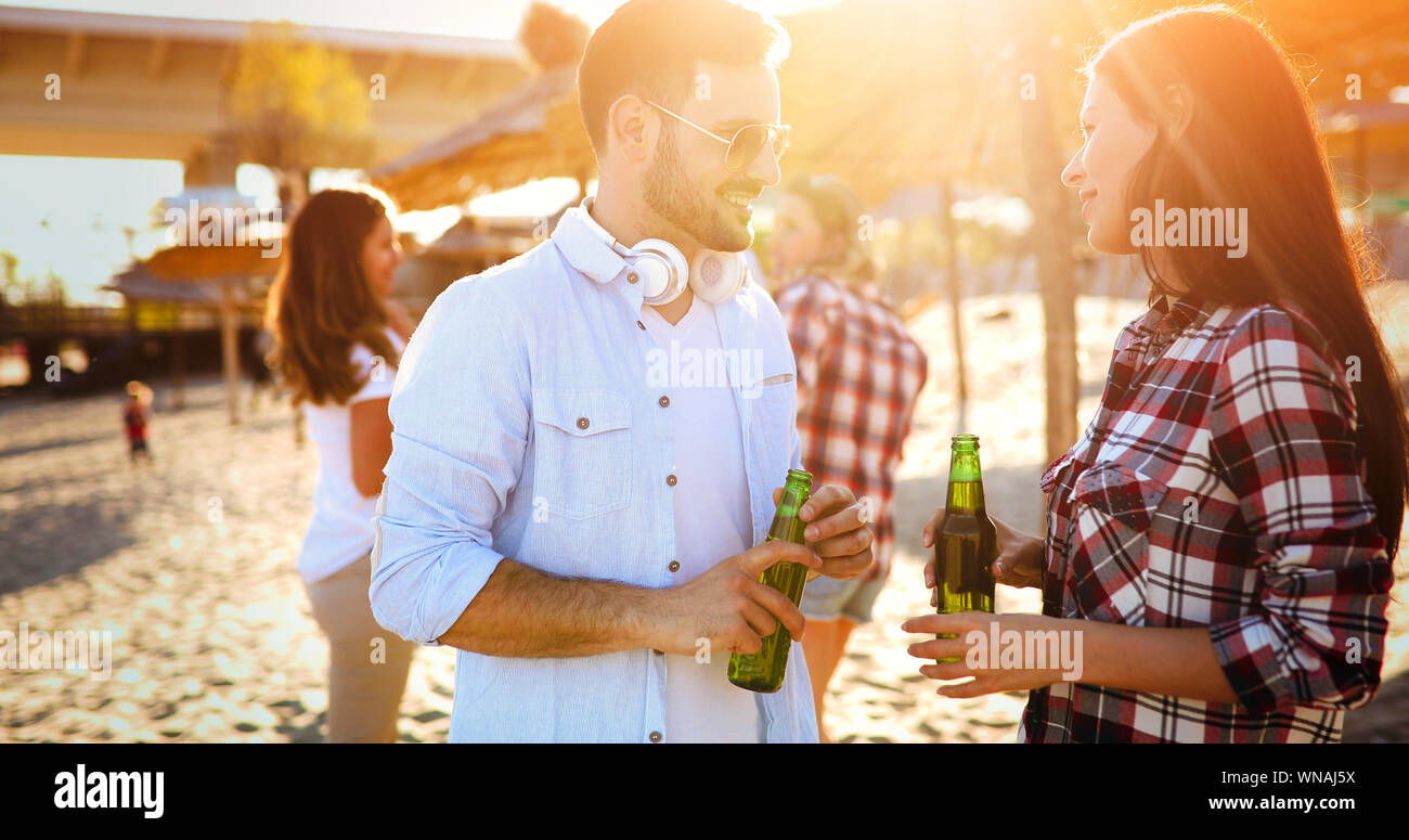 Happy young couple drinking beer and having fun at the beach Stock ...