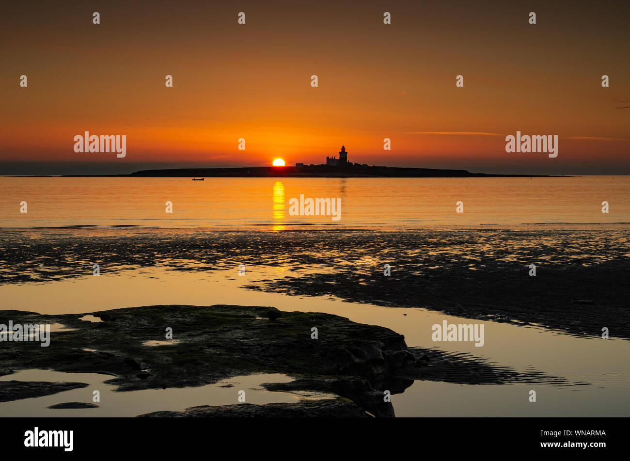 The sun rises behind coquet lighthouse on coquet island hi-res stock ...