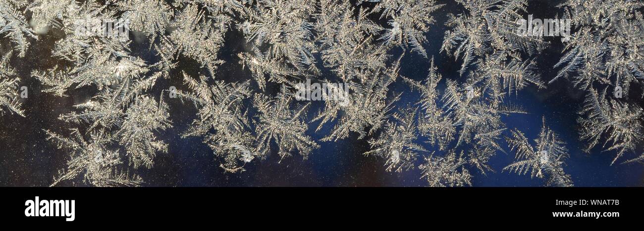 Snowflakes frost rime macro on window glass pane. Colorful ice on the ...