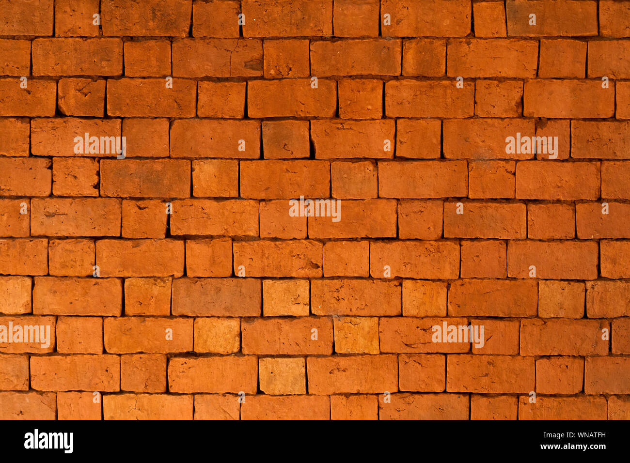 Brick wall, bright red stones from the red sand of Madagascar, Africa ...