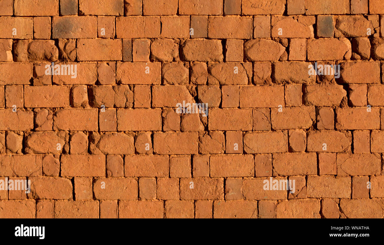 Brick wall, bright red stones from the red sand of Madagascar, Africa ...