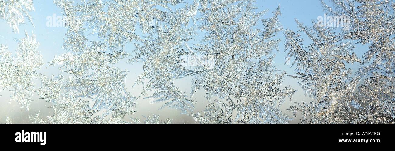 Snowflakes frost rime macro on window glass pane. Colorful ice on the ...