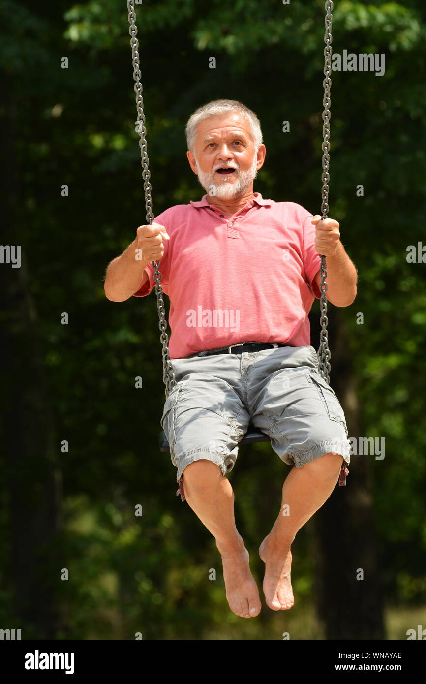 Old man swing on playground Stock Photo - Alamy