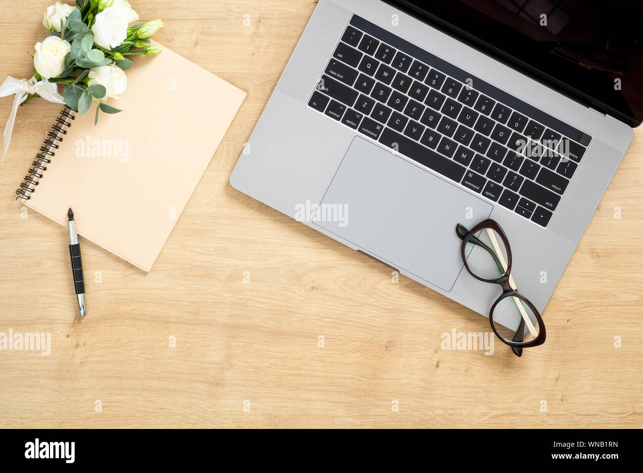 Modern wooden office desk table with laptop computer, paper notepad ...