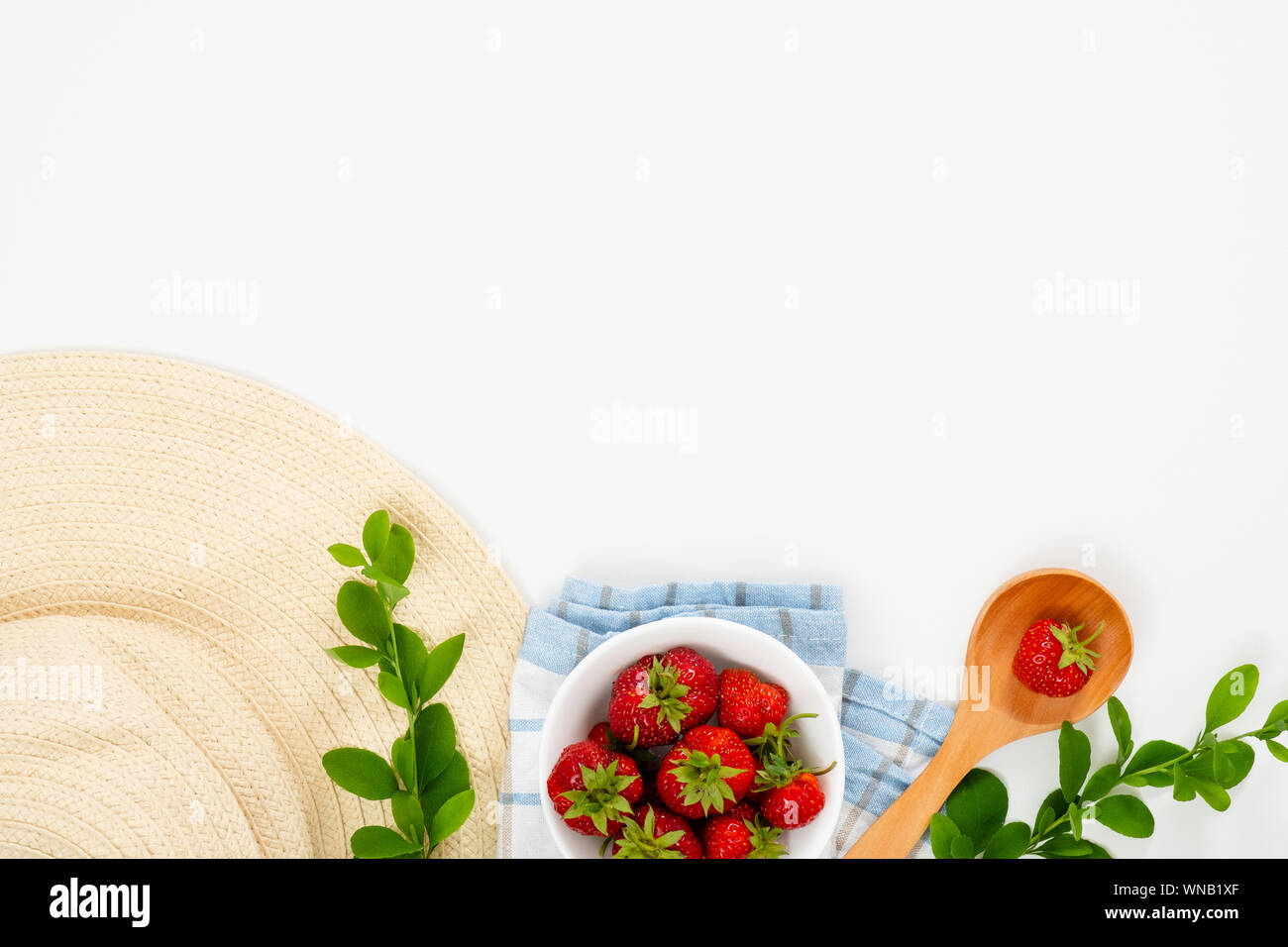 Summer morning breakfast concept with strawberry in bowl, straw hat ...