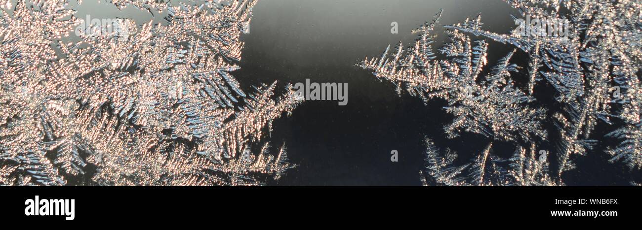 Snowflakes frost rime macro on window glass pane. Colorful ice on the ...