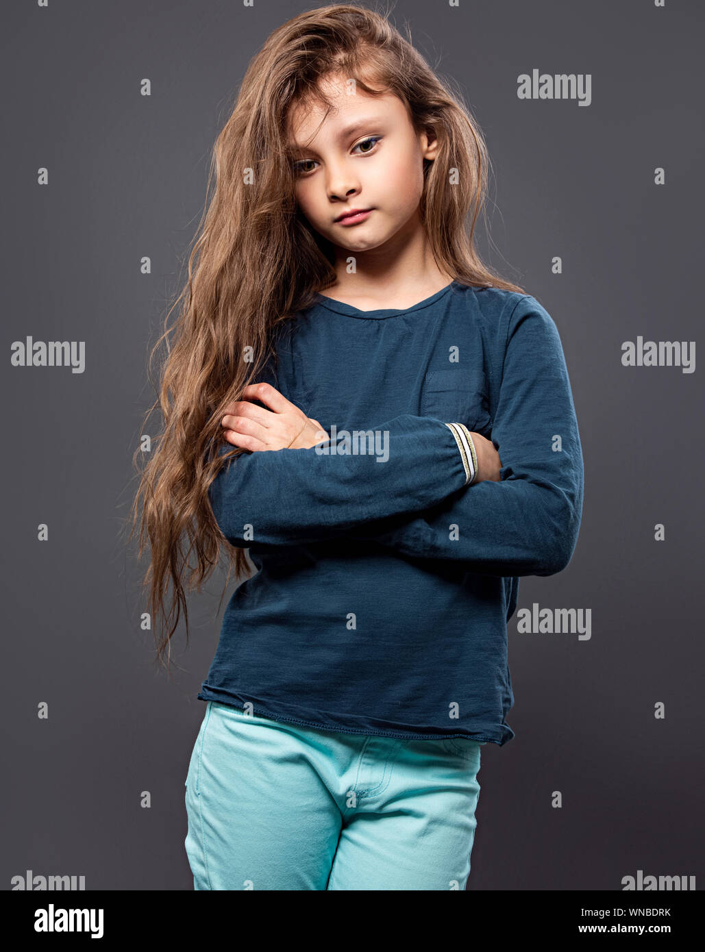 Thinking pupil kid girl with folded arms thinking and serious looking ...