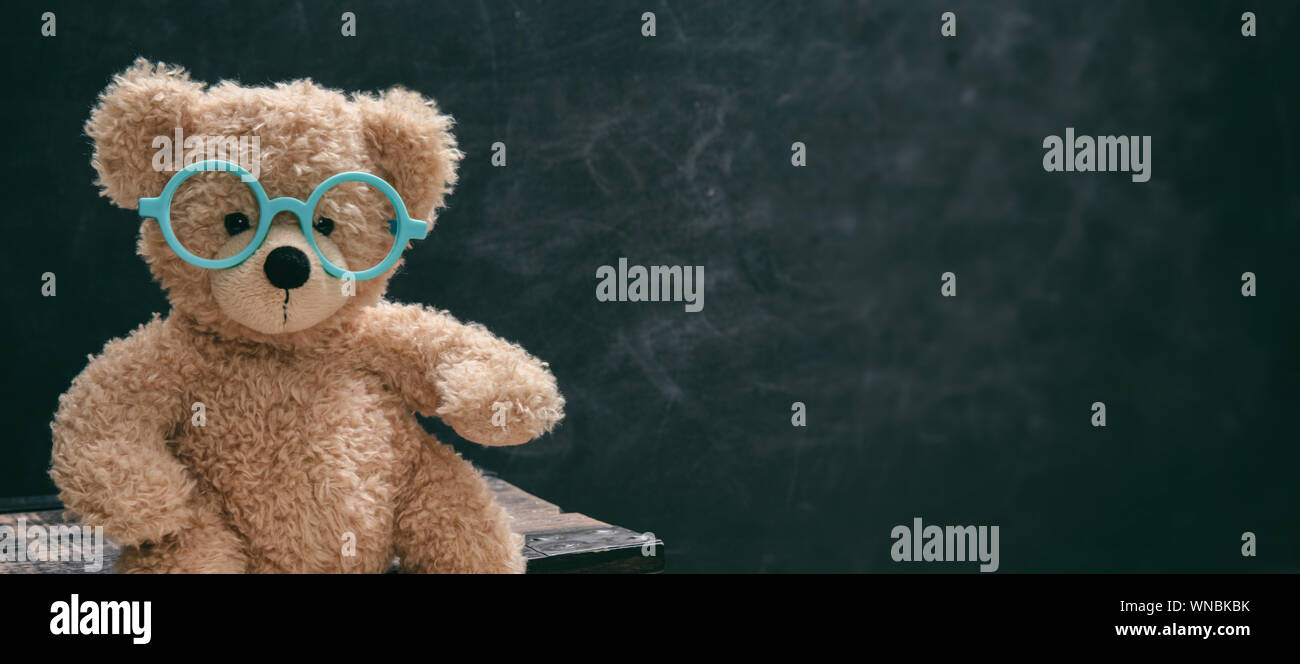 Back to school. Smart kid in class, cute teddy wearing blue eyeglasses ...