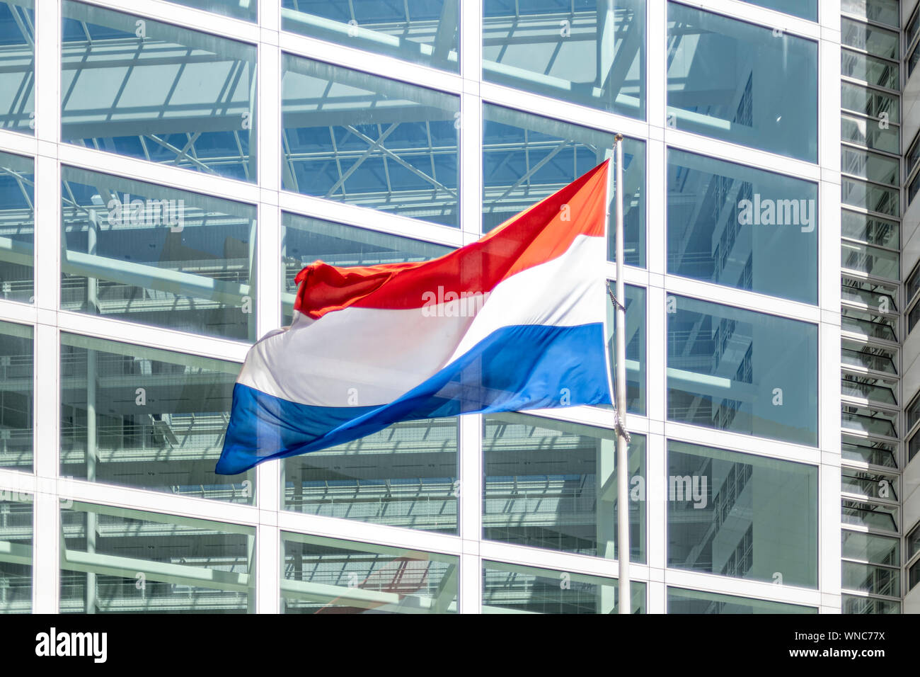 Dutch flag floating in front The Hague (Den Haag in Dutch), white glass ...