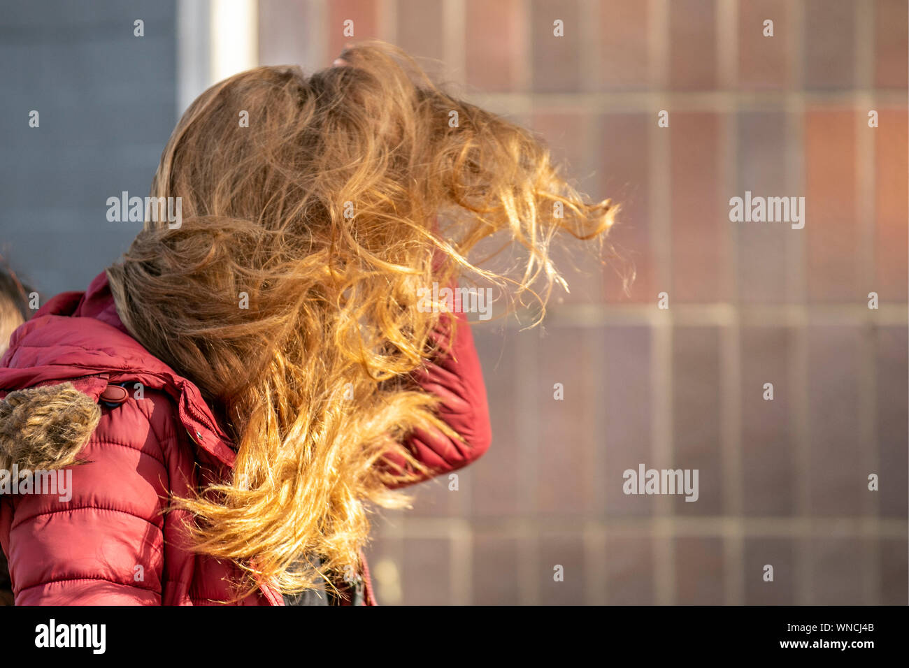 Strong winds, woman with dishevelled hair in Blackpool. A visitor to ...