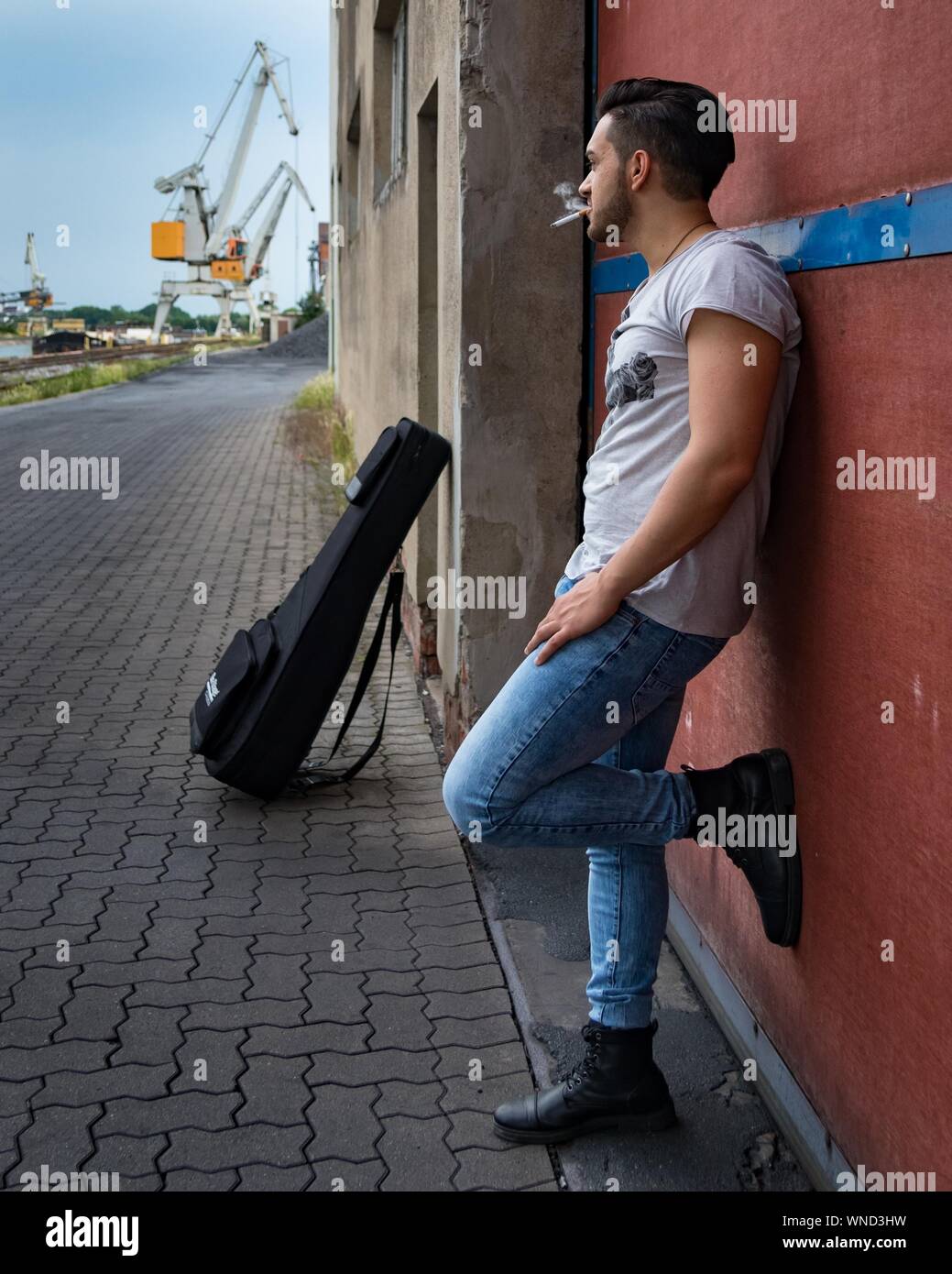 Man Leaning Against Wall Smoking Cigarette High Resolution Stock ...