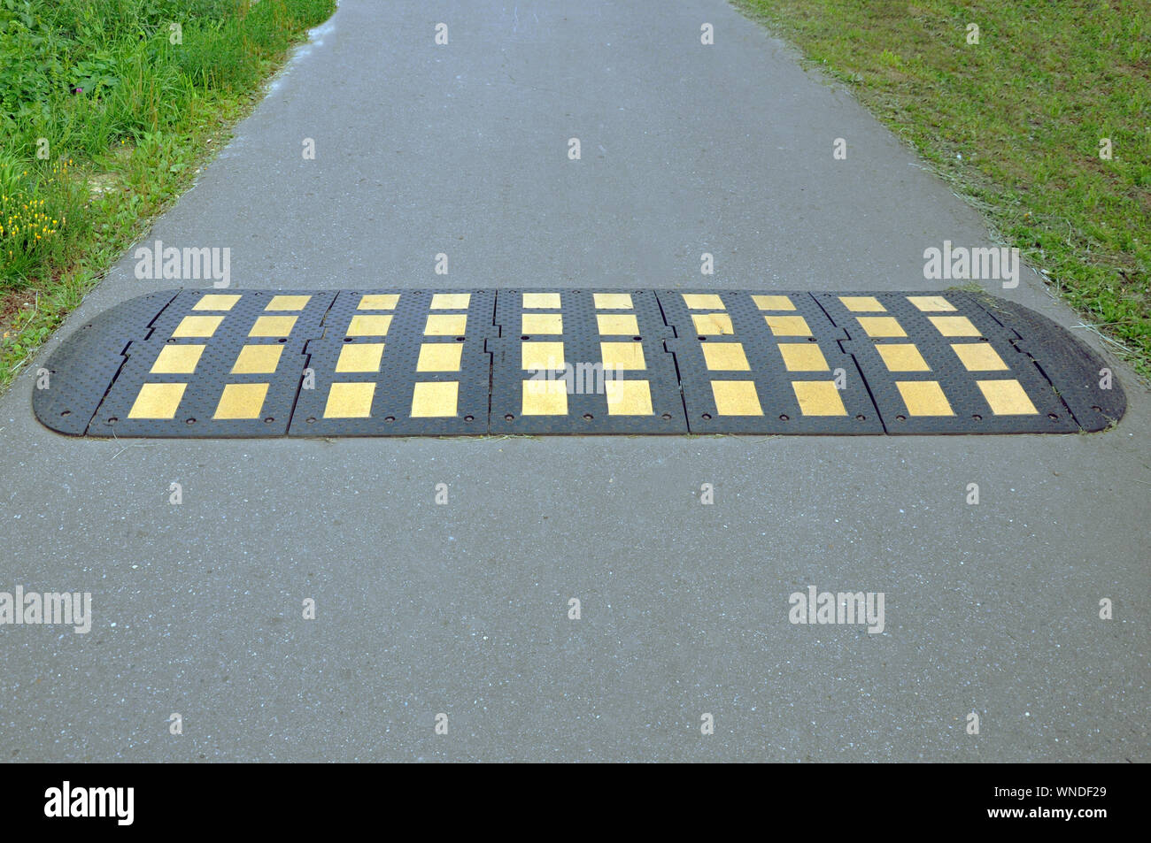Speed bump on an asphalt road in an area of individual residential ...