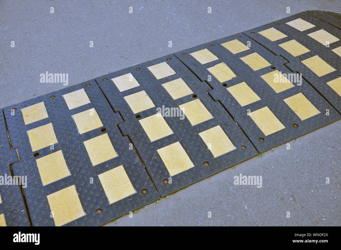 Speed bump on an asphalt road in an area of individual residential ...