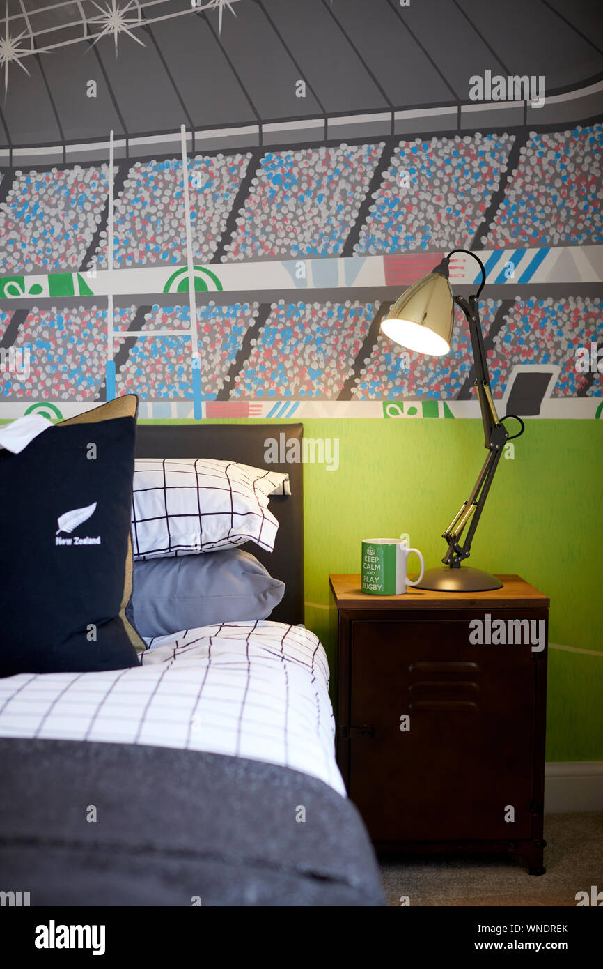 A boys bedroom with stadium mural hand painted with rugby pillow made ...