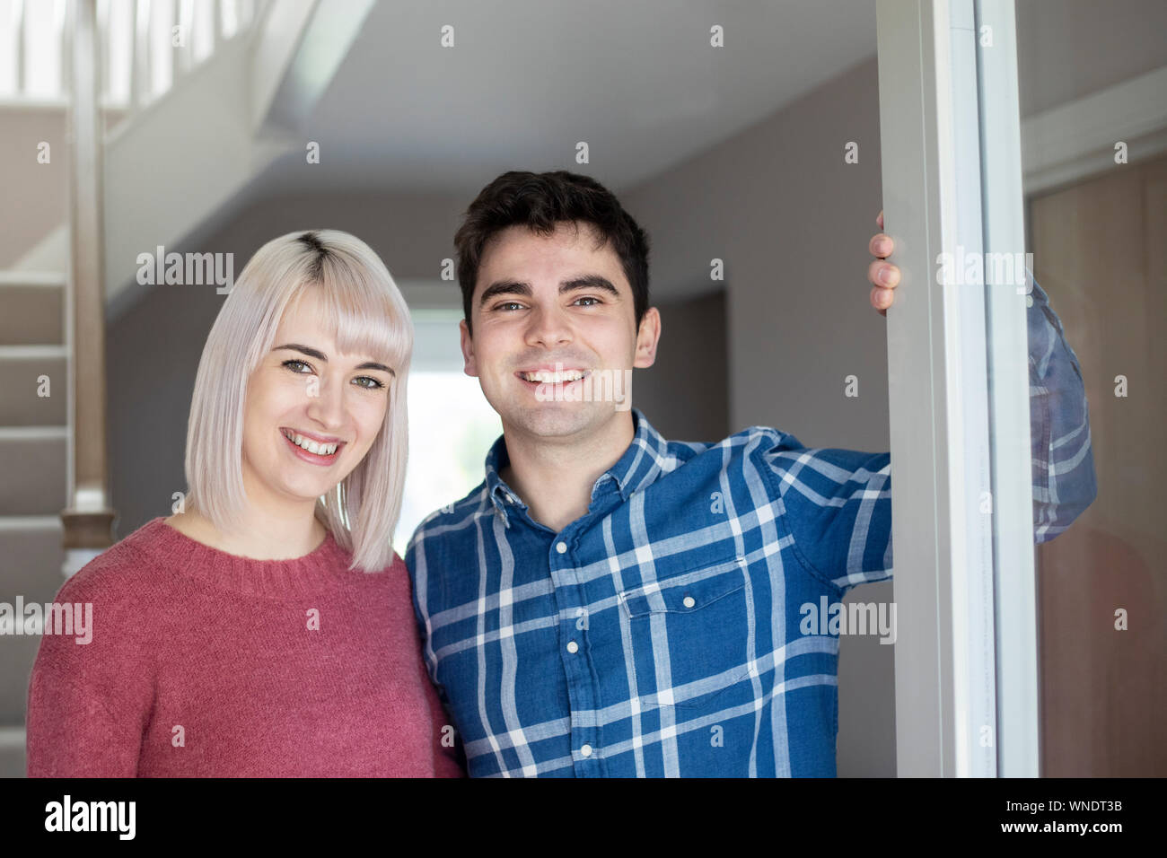 Woman opening door to man hi-res stock photography and images - Alamy