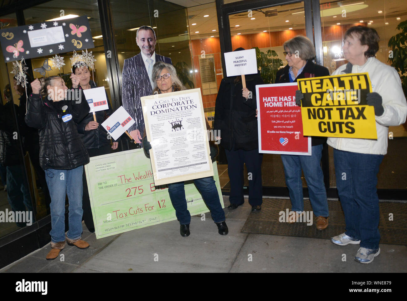 A group of people stand outside Rep. Brian Fitzpatrick's office to ...