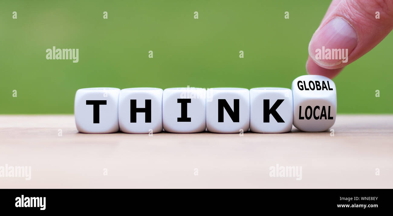 Hand turns a dice and changes the expression "think local" to "think ...