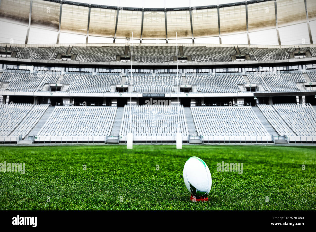 Composite image of rugby ball on a stand in stadium Stock Photo - Alamy