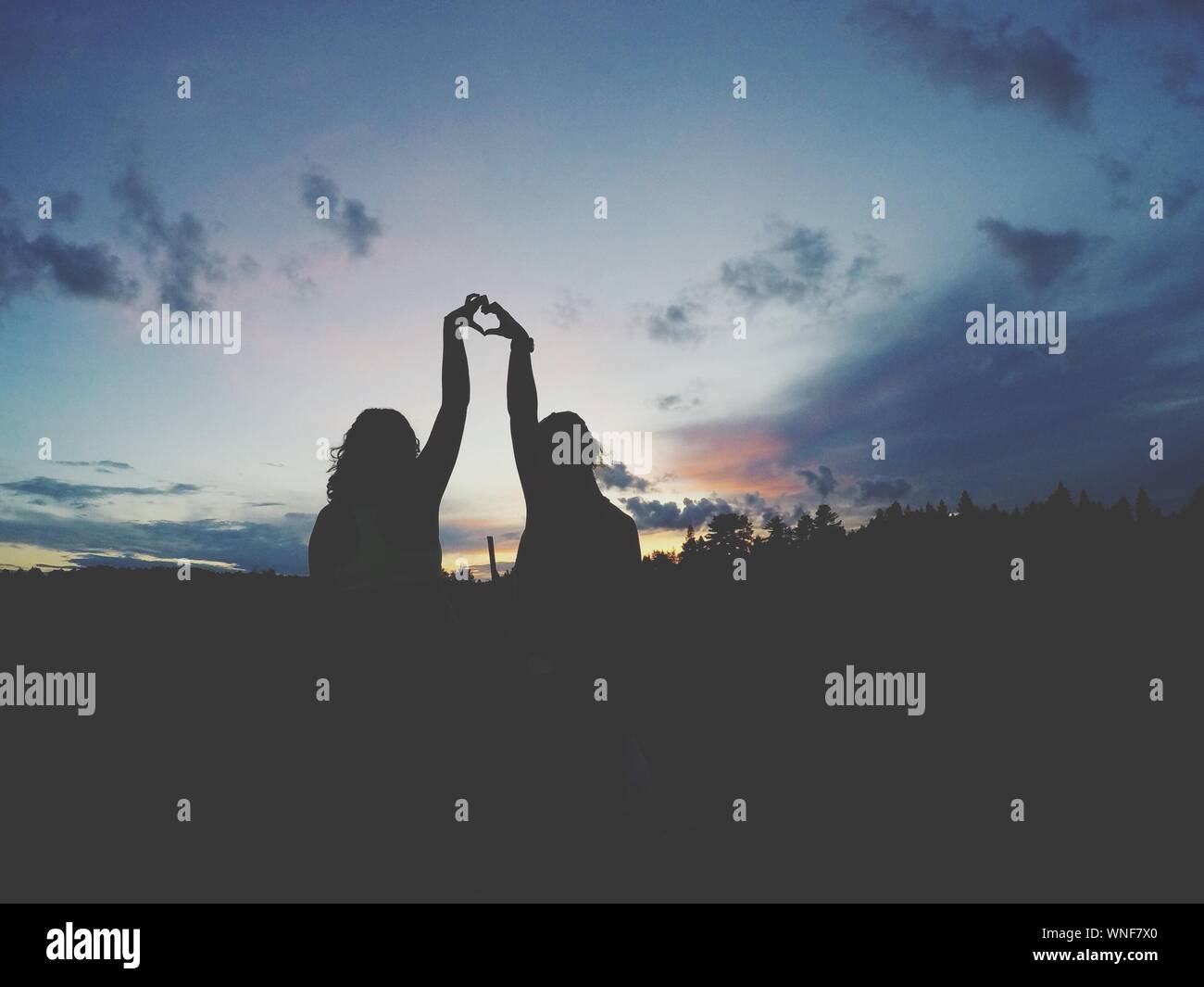 Friends making heart shape hands hi-res stock photography and images ...