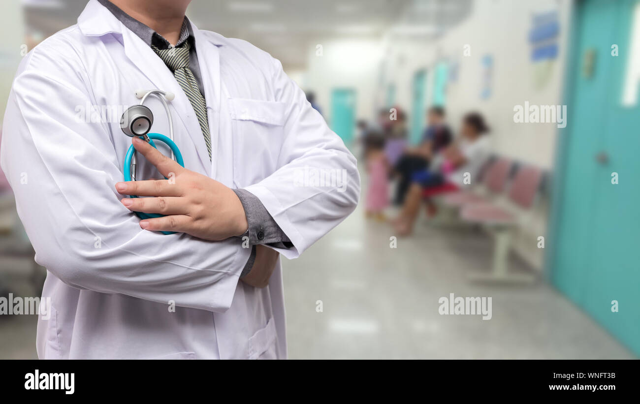 Doctor in gown uniform with stethoscope standing and fold his arms over ...