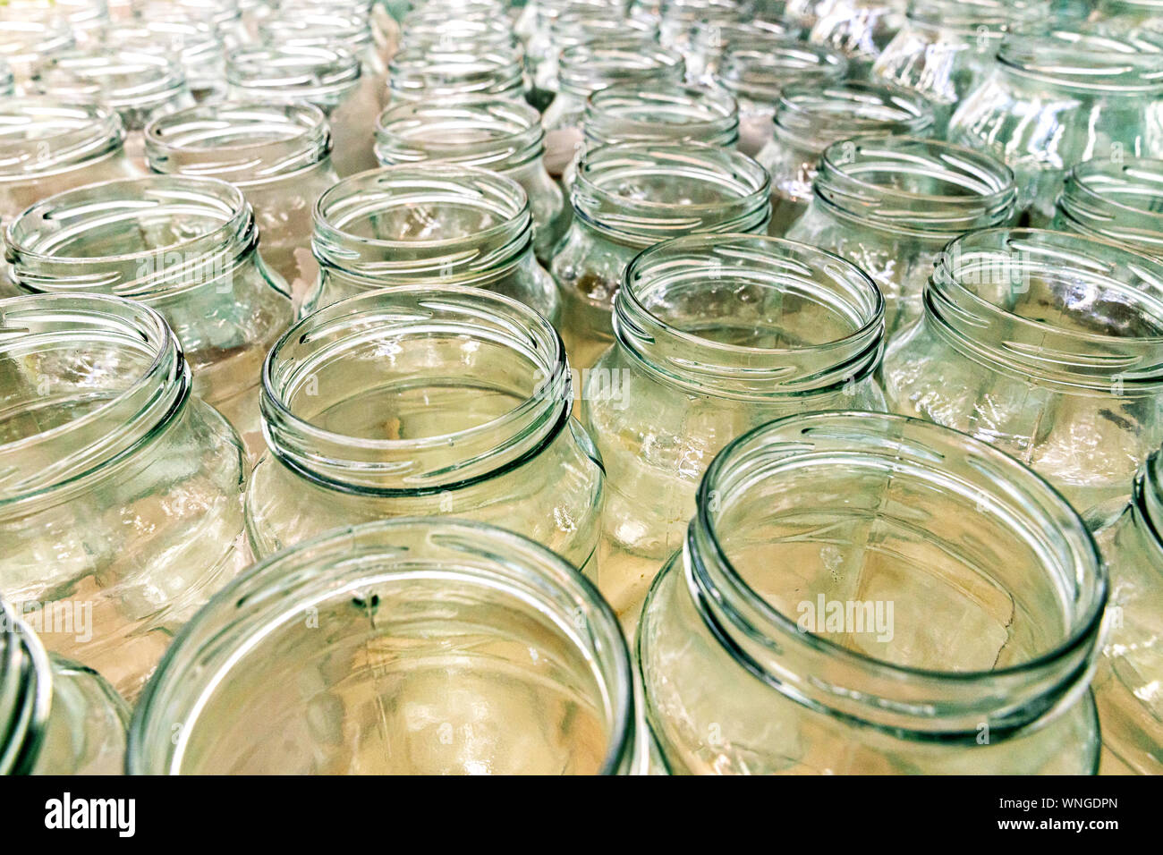 Lots of empty transparent jars in rows background Stock Photo - Alamy