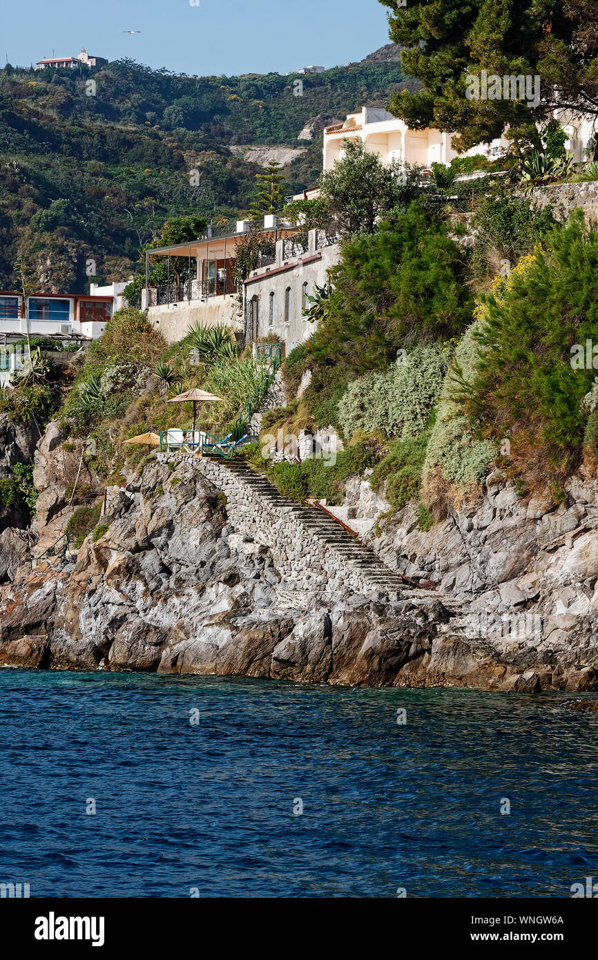 houses on cliff, Mediterranean Sea; blue water, stone steps down ...