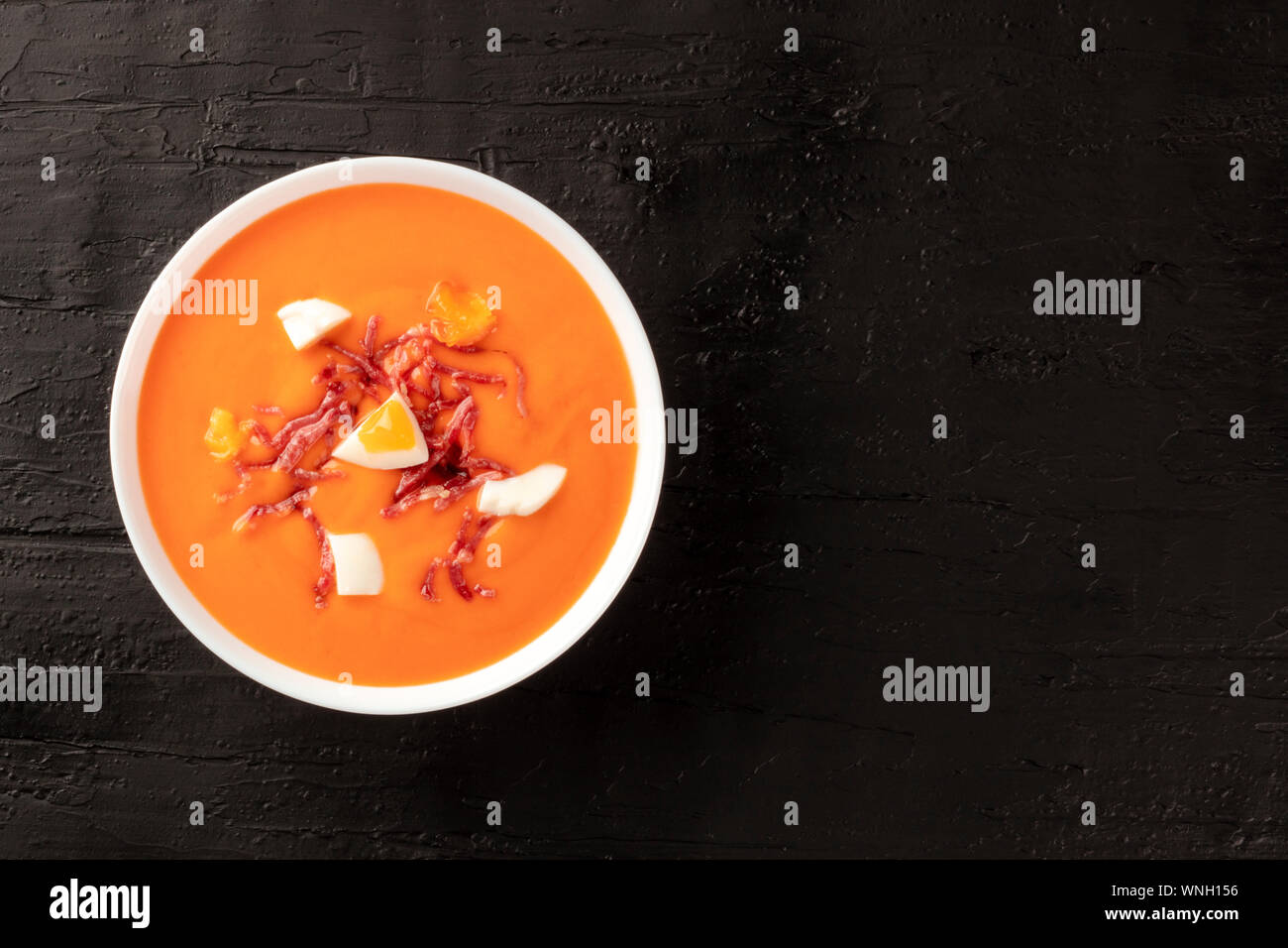 Salmorejo, Spanish cold tomato soup, overhead shot on a black ...