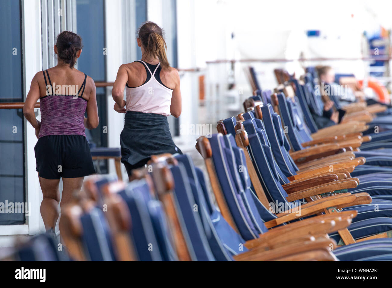 Two female joggers taking an early morning jog around the deck of a ...