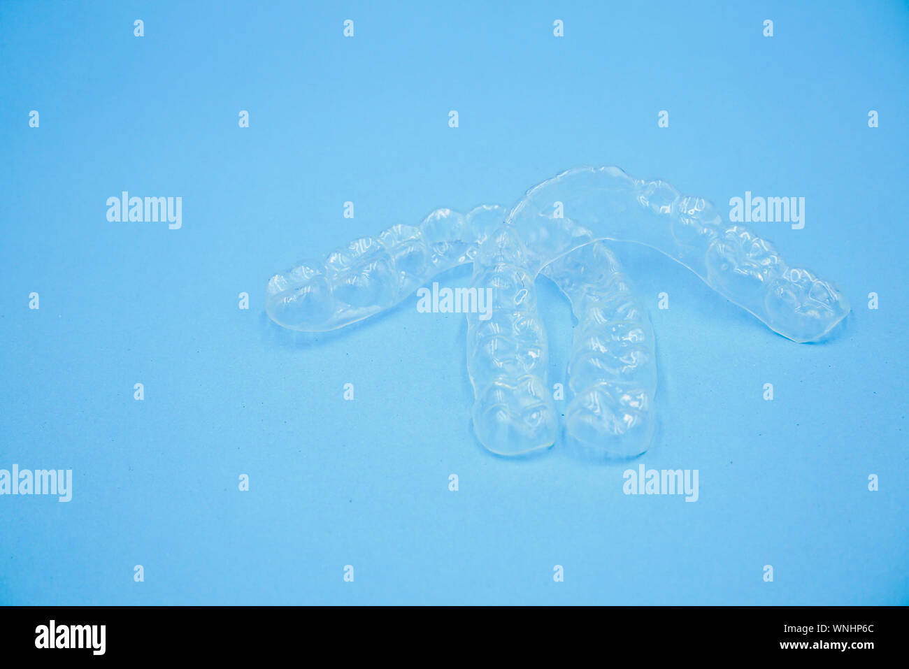 clear plastic retainer teeth that isolated on blue sky background. it's ...