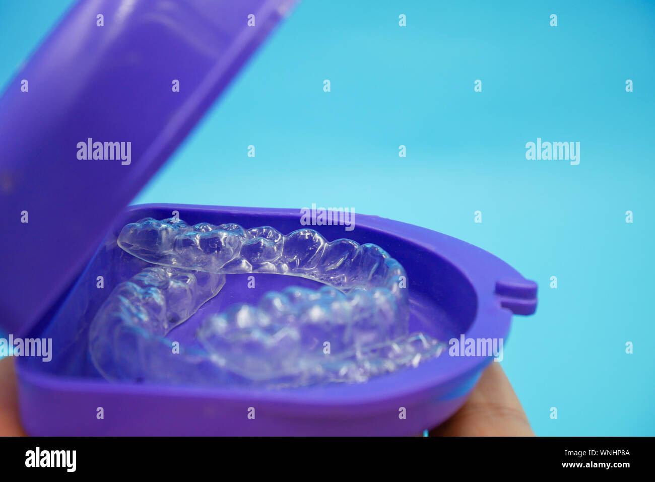 clear plastic retainer teeth in the box set isolated on blue sky ...