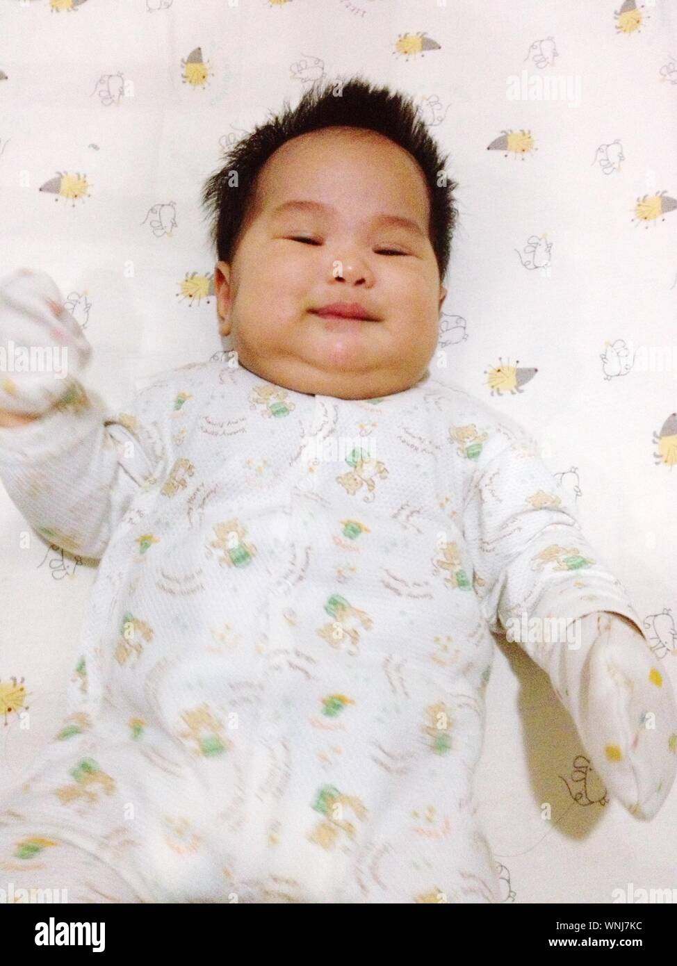 Portrait of baby girl lying on bed hi-res stock photography and images - Alamy