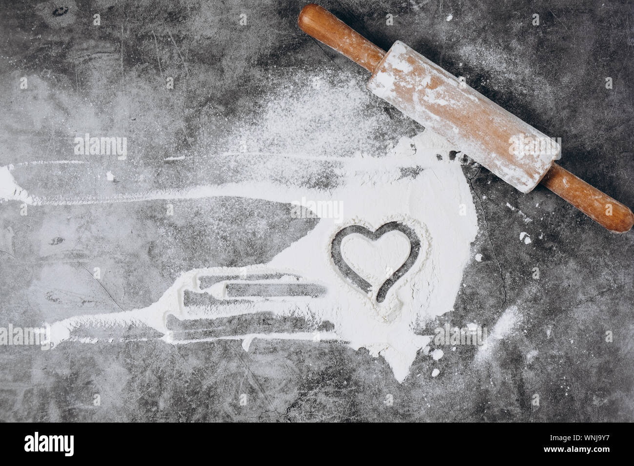 Baking background. Heart of flour and rolling pin on gray table. Bake ...