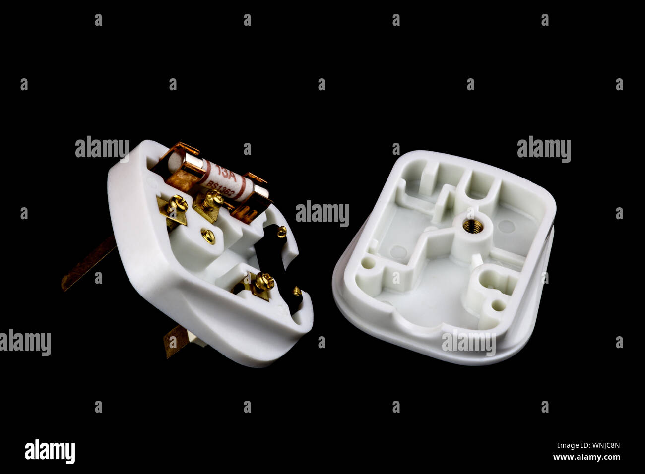 Opened UK specification electrical plug isolated against a black ...