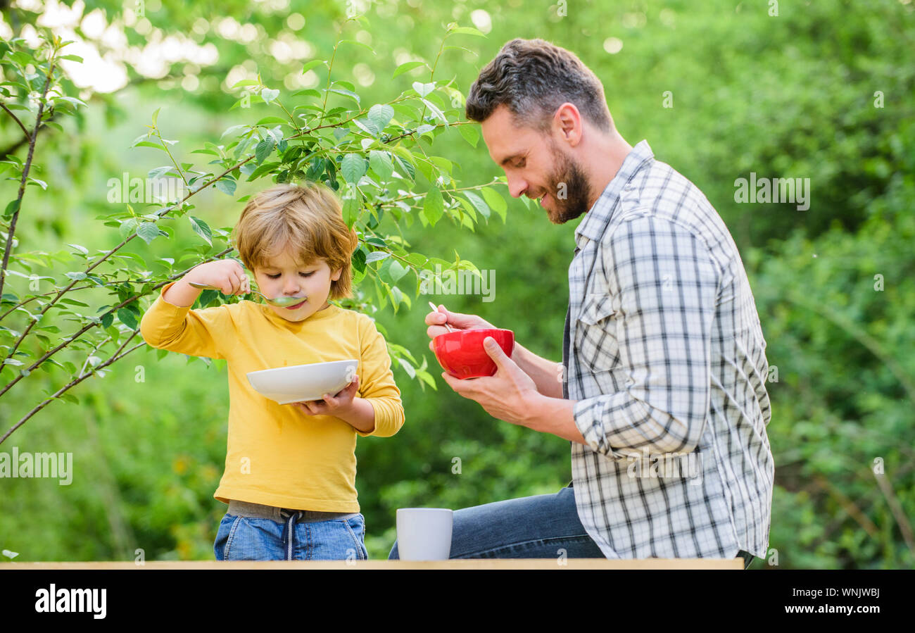 son and father eating outdoor. Happy family together. weekend morning ...