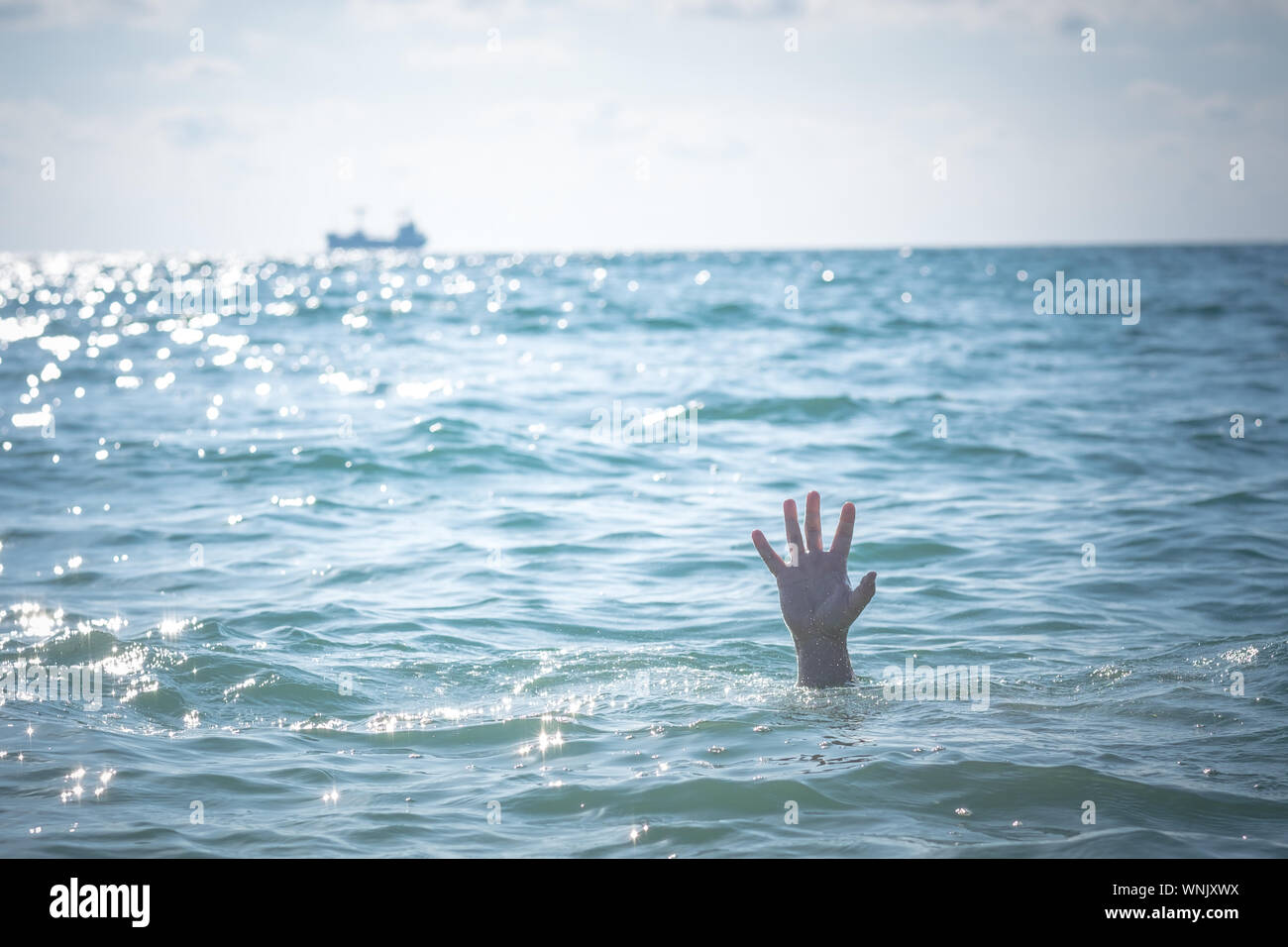 single hand of drowning man in sea asking for help. sticking out of the ...