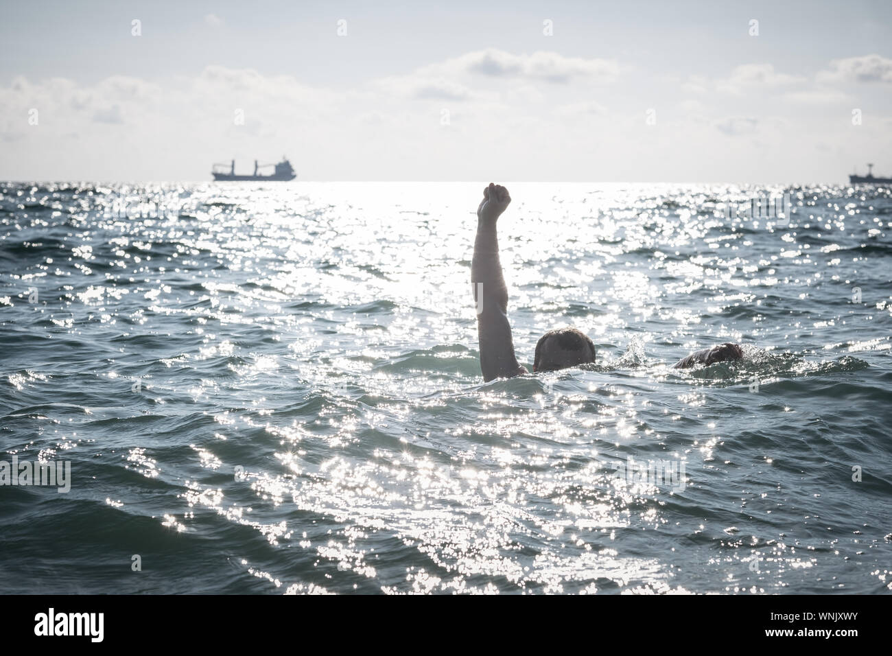 single hand of drowning man in sea asking for help. sticking out of the ...