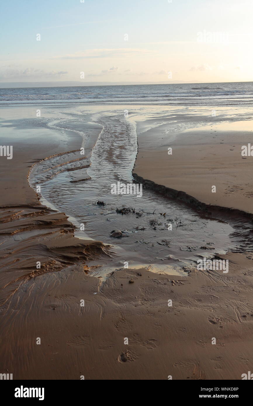The place where a fresh water springs enters the sea on a sandy beach ...