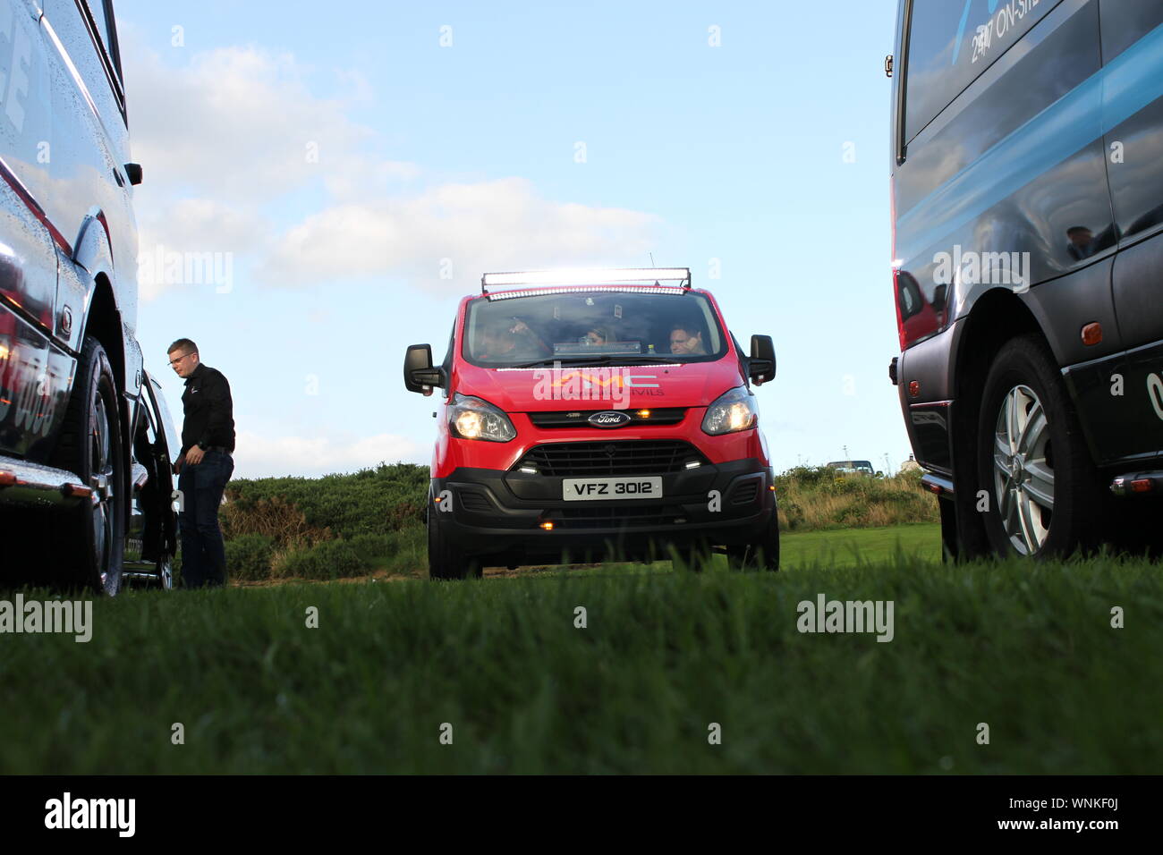 Red Ford Transit Van Viewed between two black Mercedies Sprinter Vans ...
