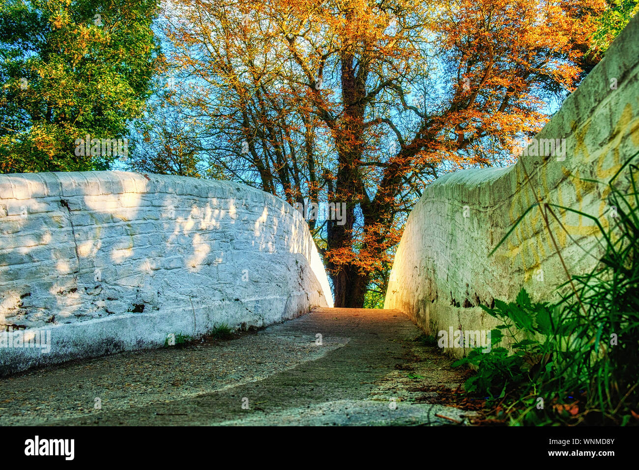 Close up of a white painted brick bridge spanning over the river Gade ...