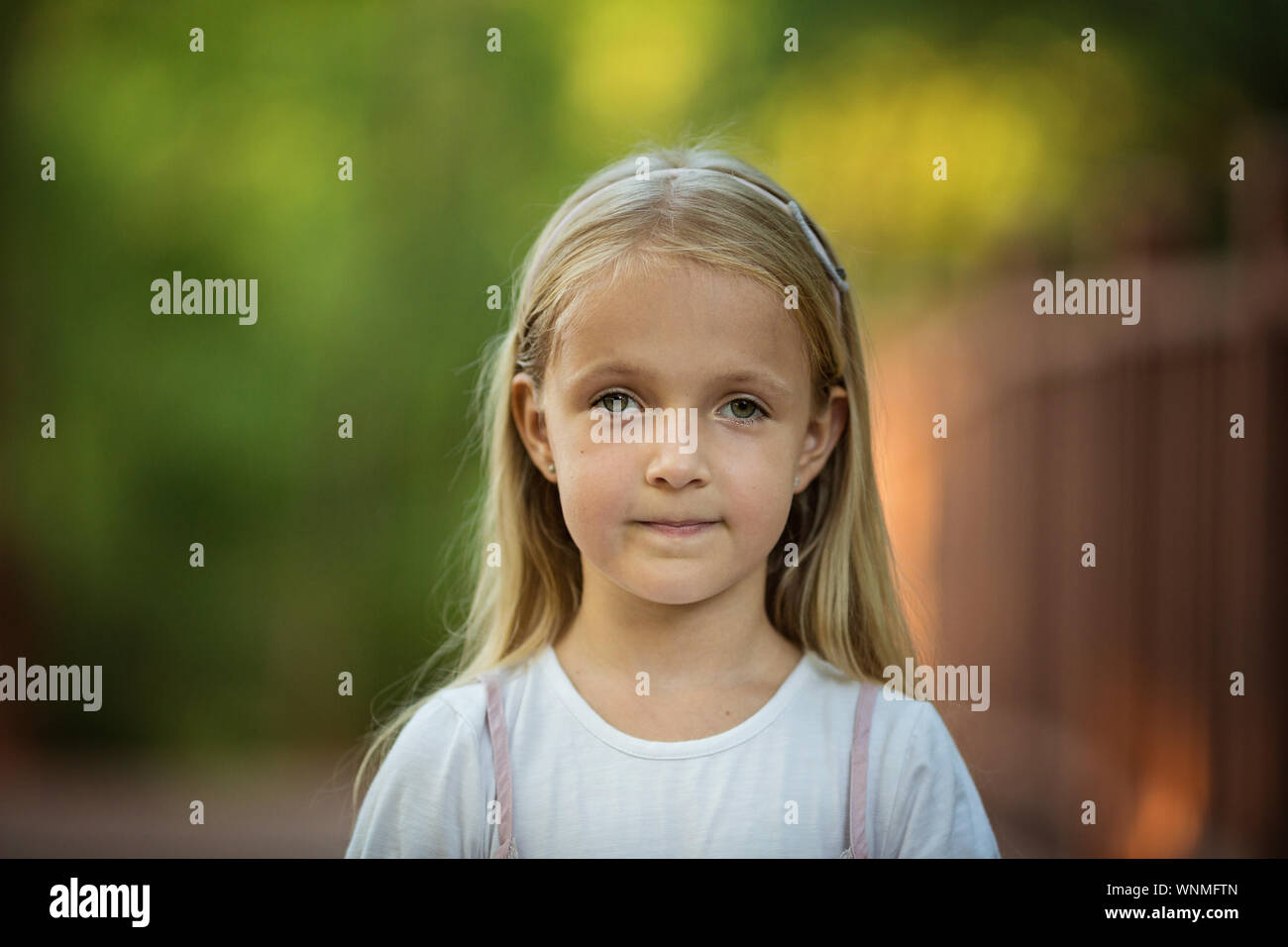 Portrait of adorable little girl with long blonde hair in the park ...