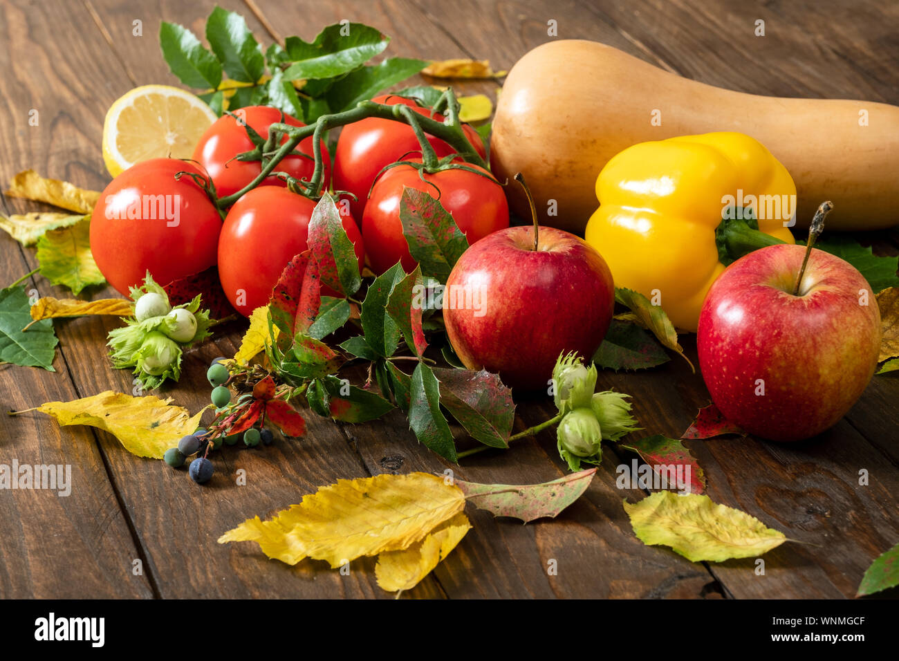 Tomato, yellow pepper, squash, hazel nut and autumn leaves closeup ...
