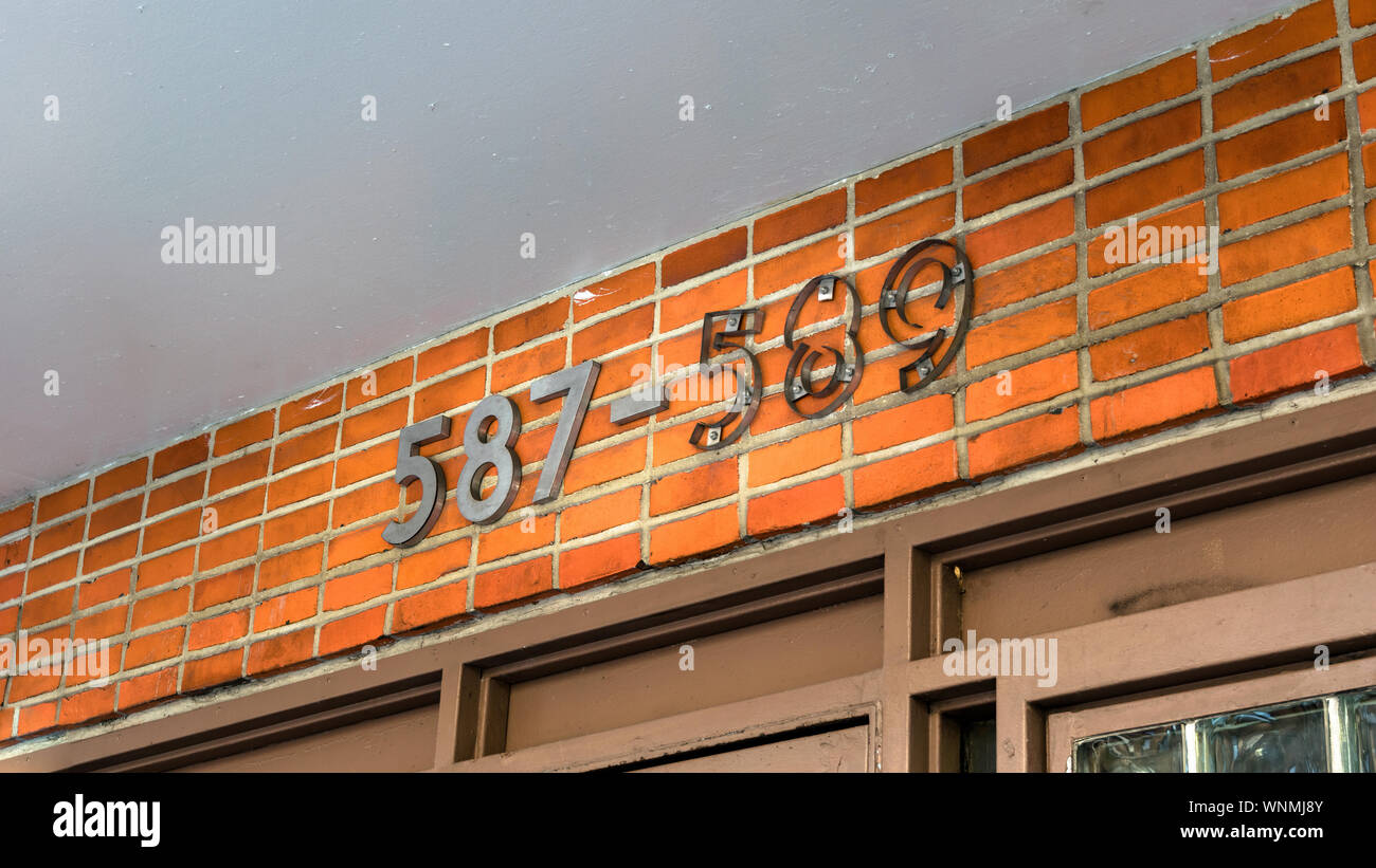 Old building number on a brick wall with some of the numbers missing ...