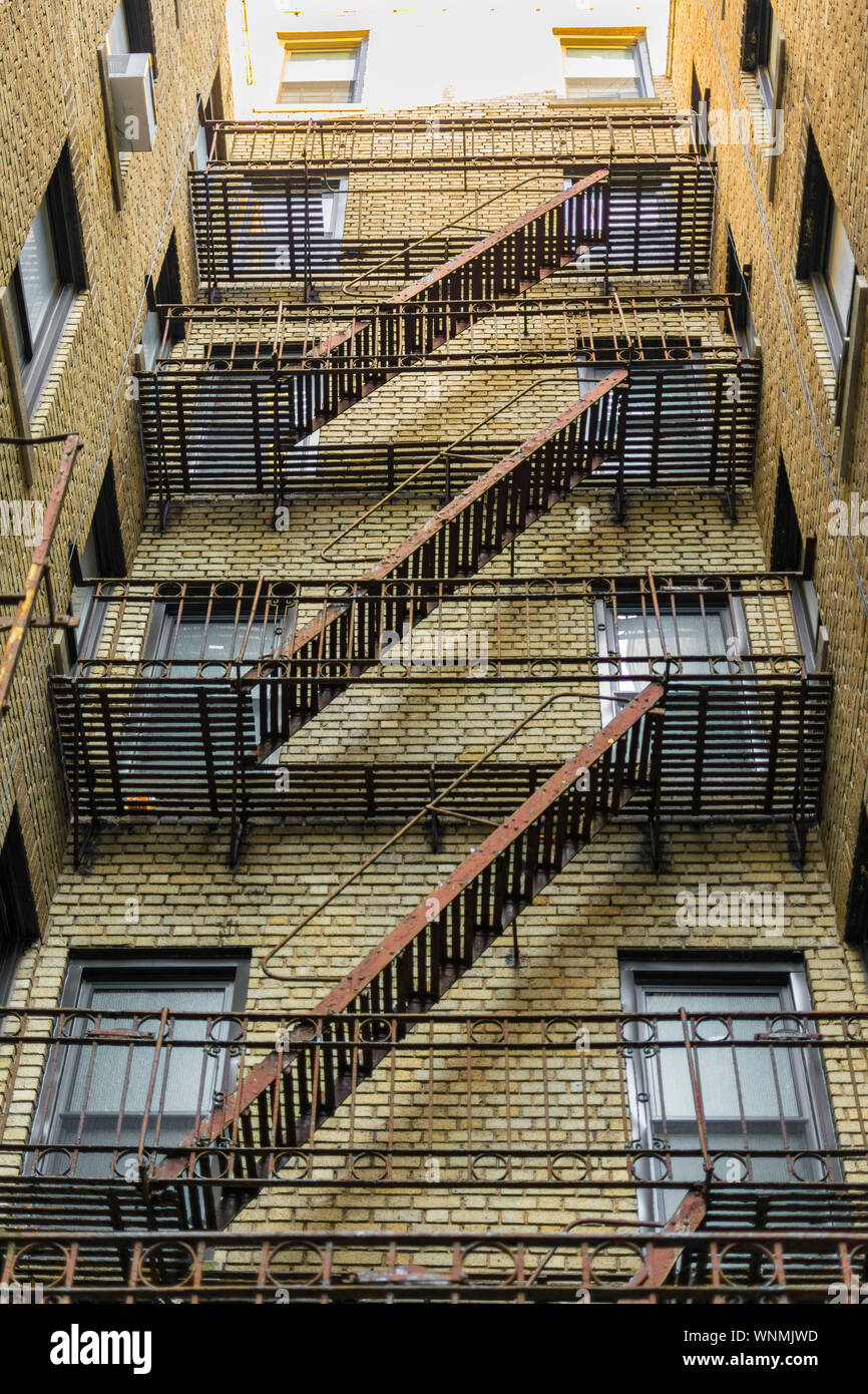 Facade of a brownstone with an old rusty fire escape Stock Photo - Alamy