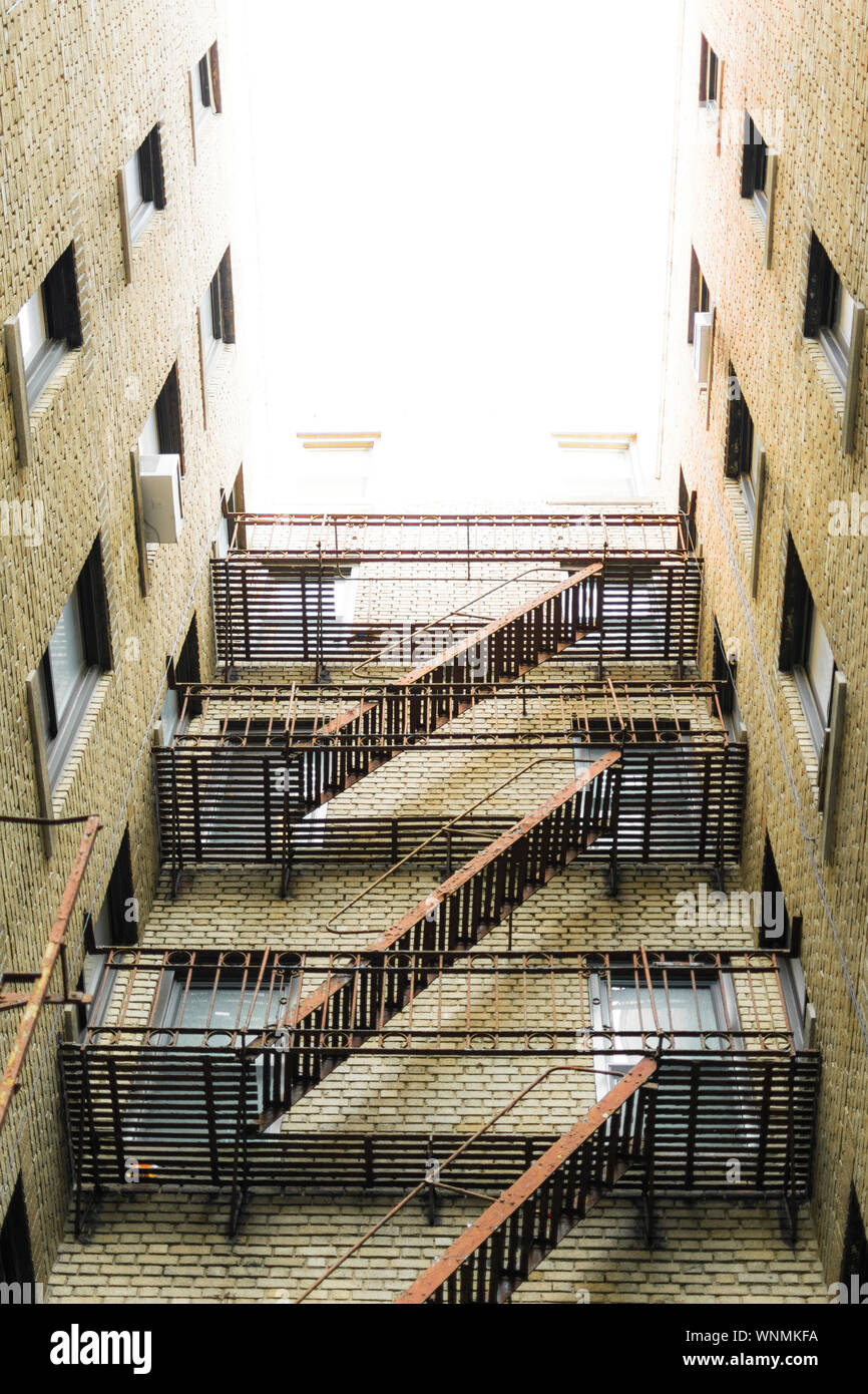 Facade of a brownstone with an old rusty fire escape Stock Photo - Alamy