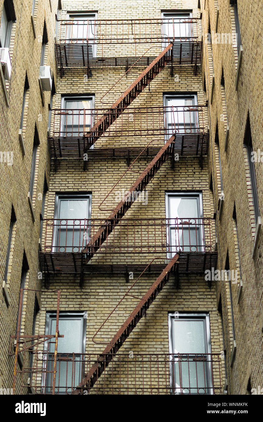 Facade of a brownstone with an old rusty fire escape Stock Photo - Alamy