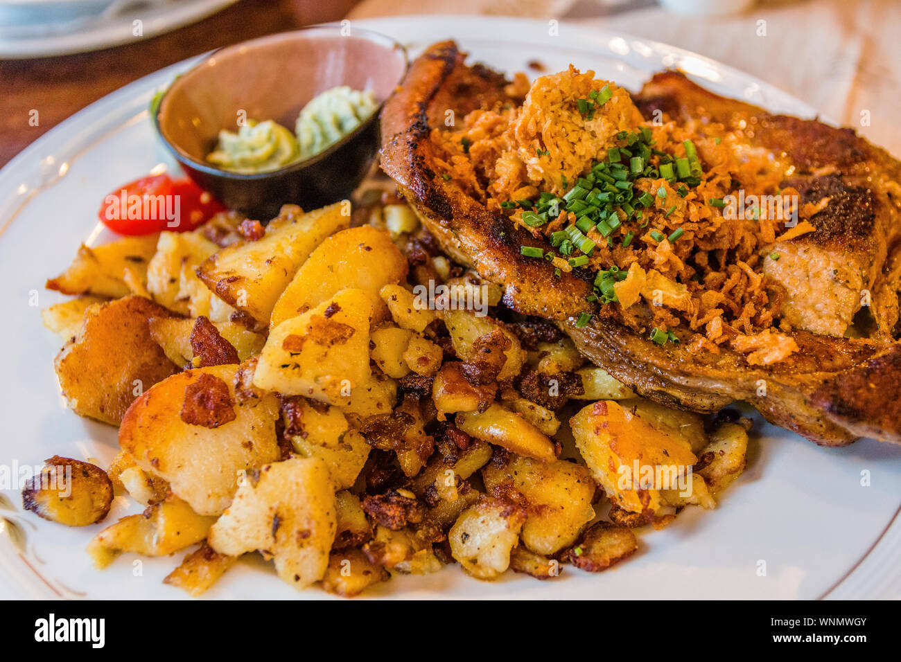 Traditional german dish. Roasted pork with potatos, fried onion and ...