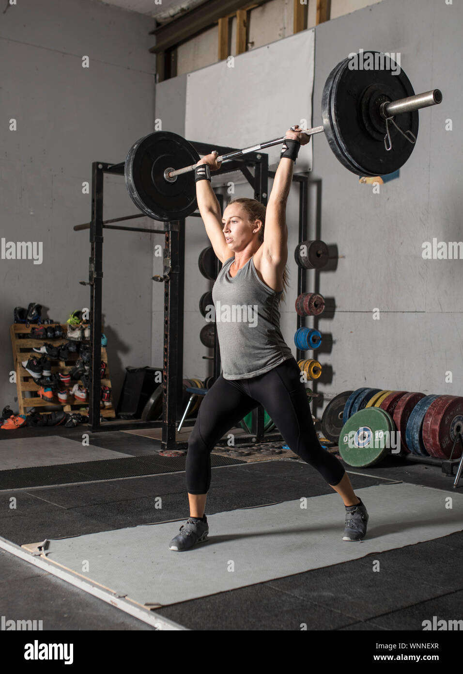 Strong female weight lifter with heavy barbell over her head Stock ...